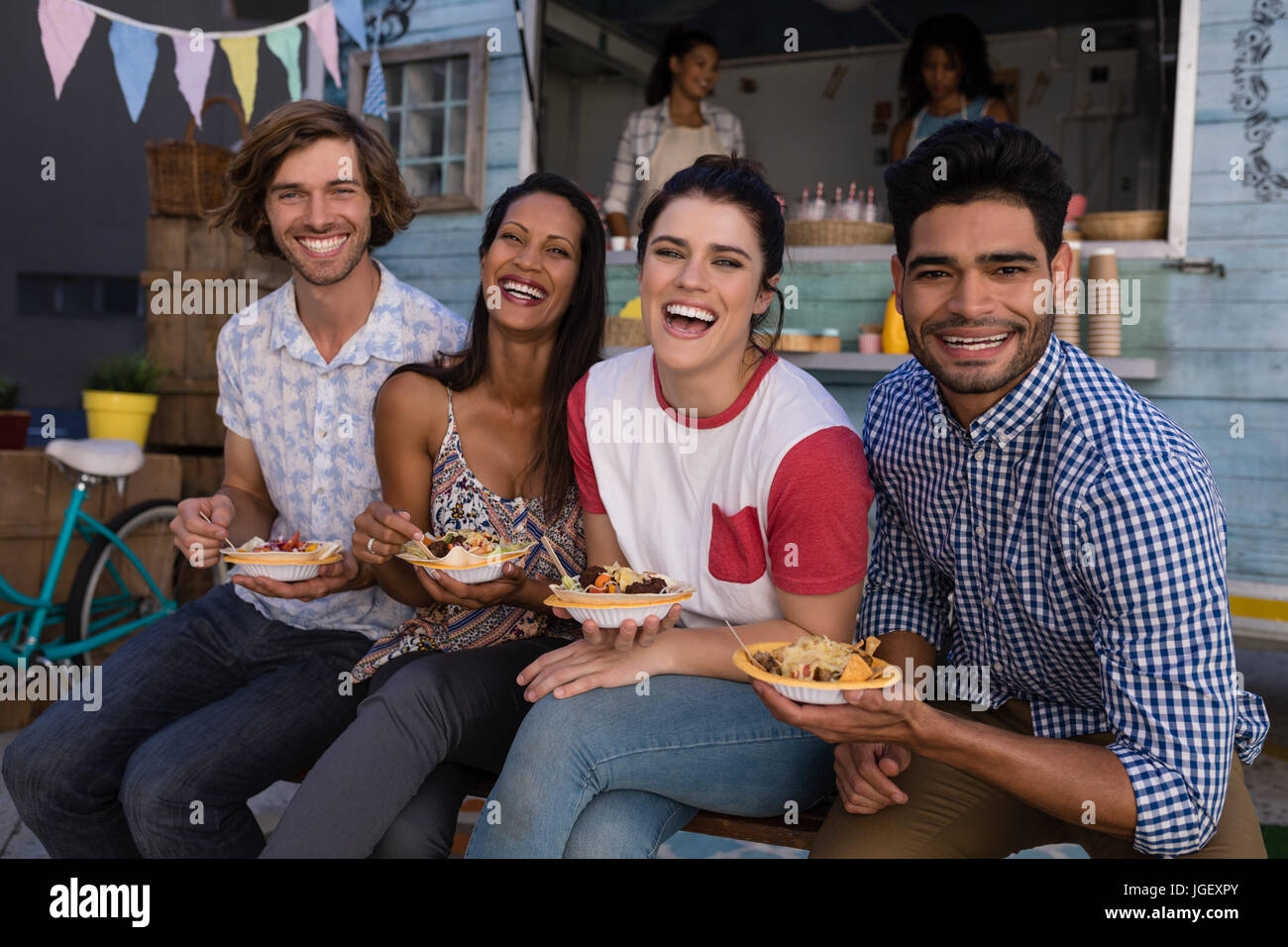 Portrait of smiling friends sitting with snacks Stock Photo - Alamy