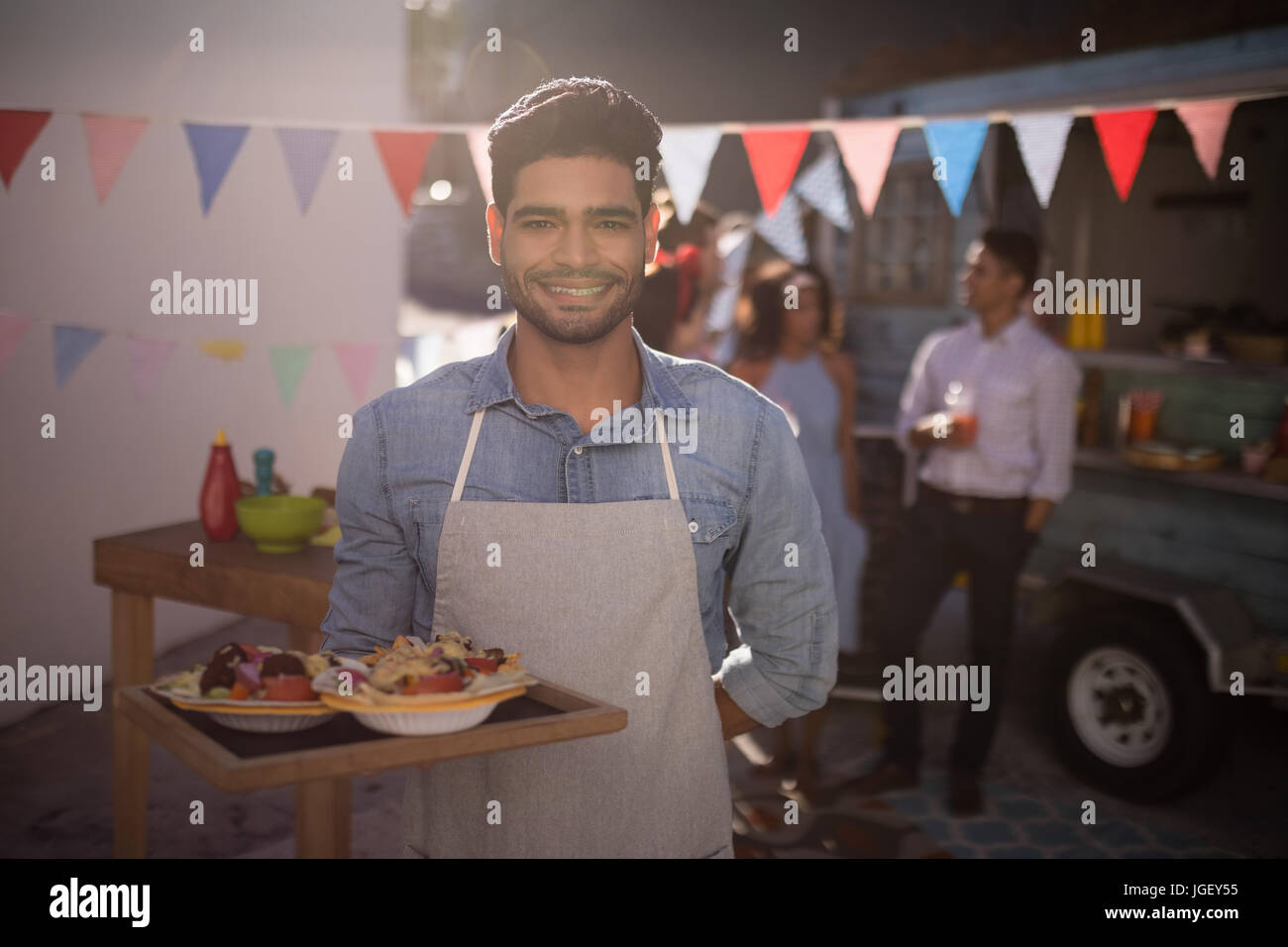 Portrait of happy waiter holding food in tray Stock Photo - Alamy