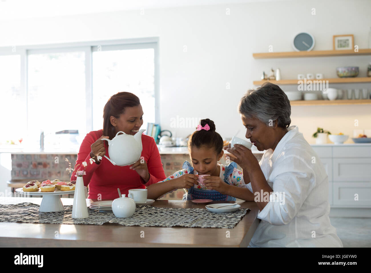 Happy multi-generation family having tea in dining table at home Stock ...
