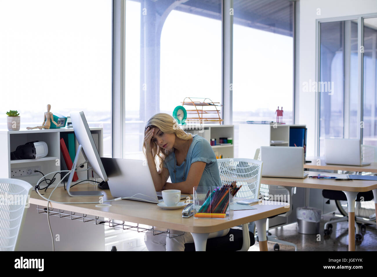 Stressed female executive working at her desk in office Stock Photo - Alamy
