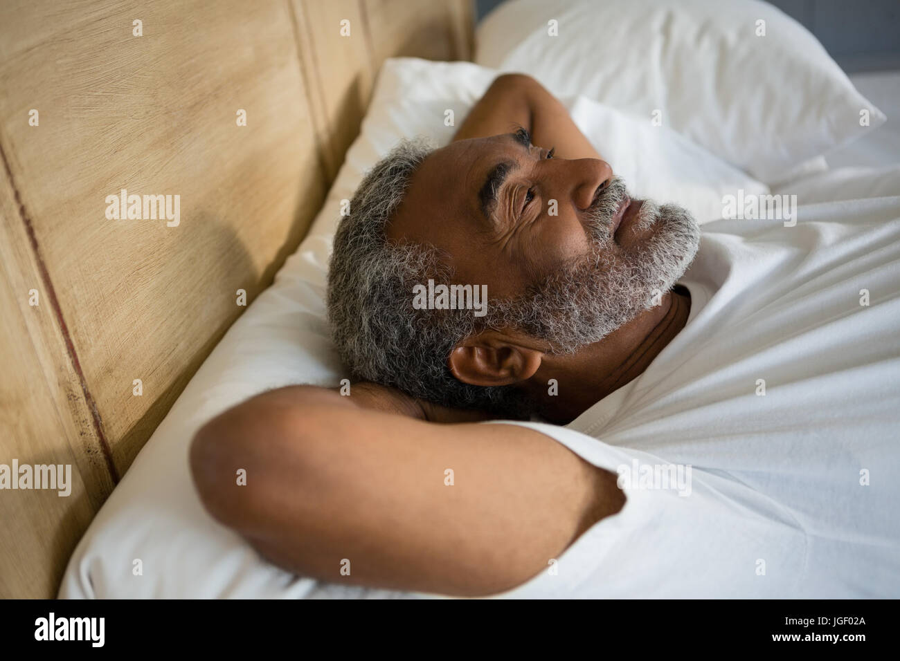 Senior man relaxing on bed in the bedroom at home Stock Photo - Alamy