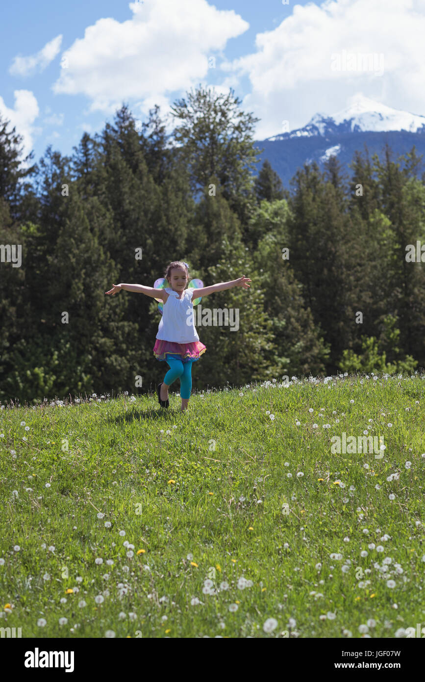 Excited girl with arms outstretched running in park Stock Photo - Alamy