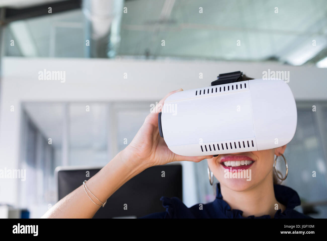 Female executive using virtual reality headset in office Stock Photo ...