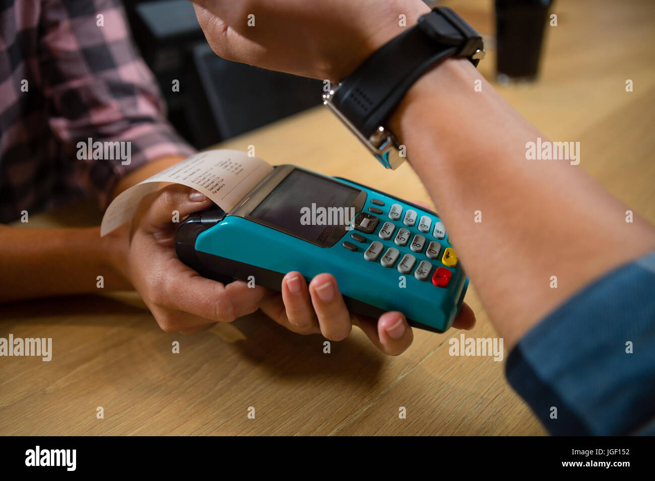 Cropped hand of male customer making payment through contactless ...