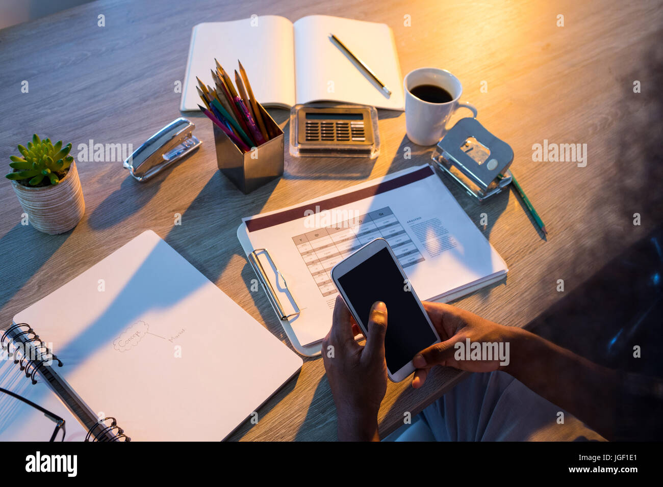 Male executive using mobile phone at his desk in office Stock Photo - Alamy