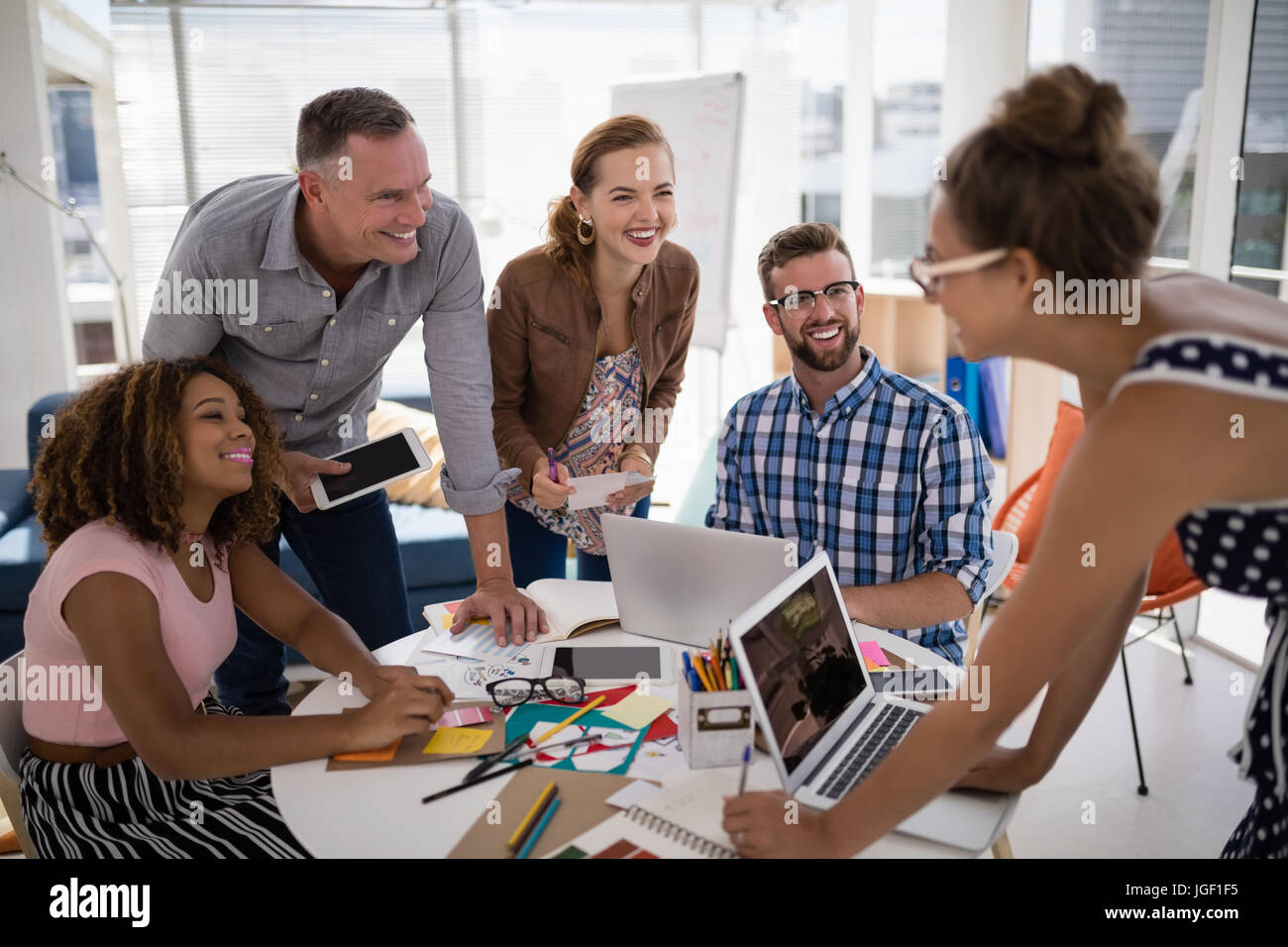 Smiling team of executives working together in the office Stock Photo ...
