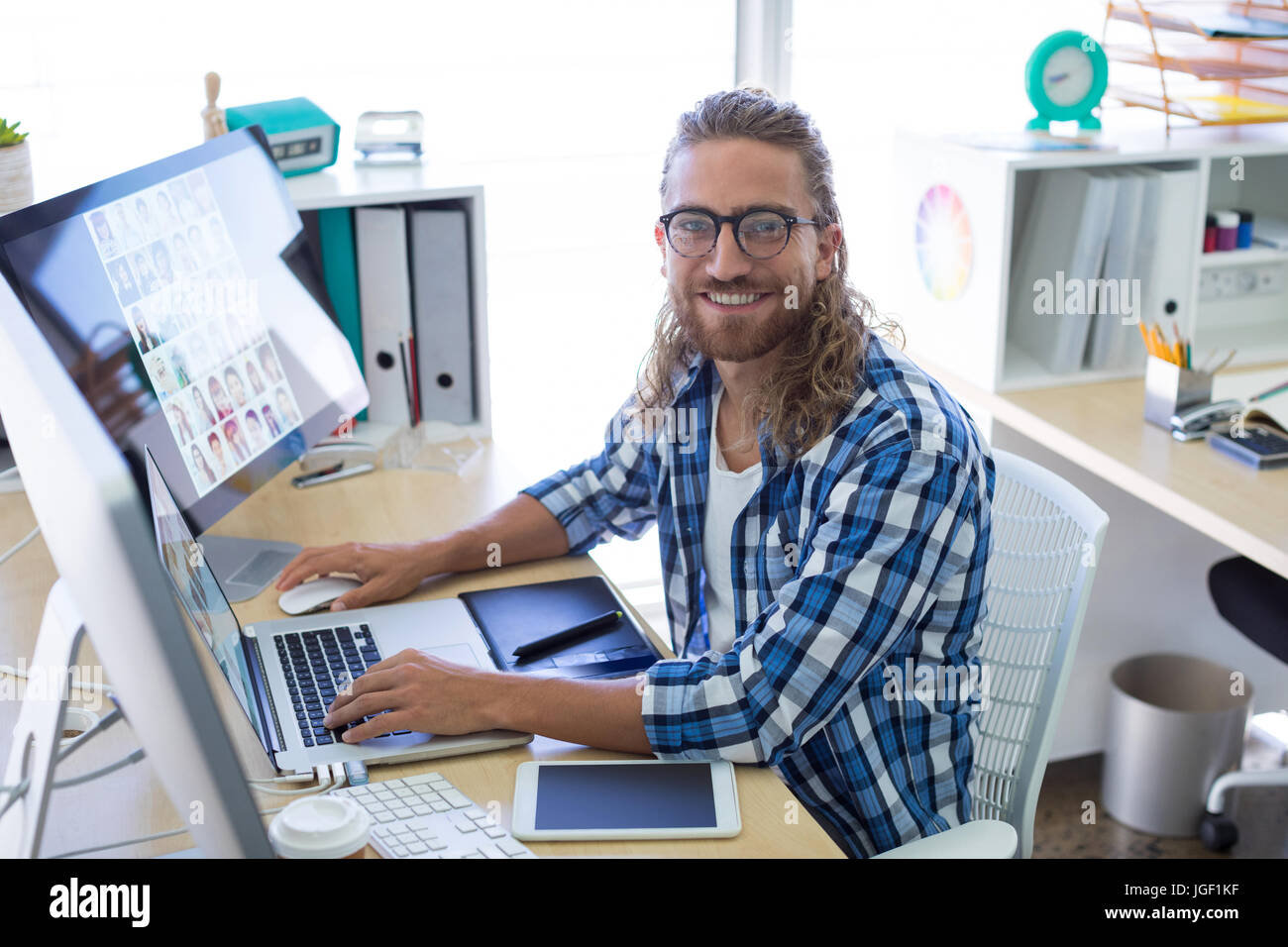 Portrait of male executive sitting at his desk in office Stock Photo ...