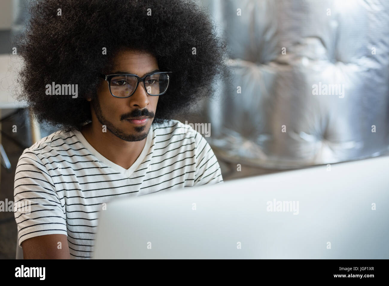 Concentrated man using computer while working at creative office Stock ...