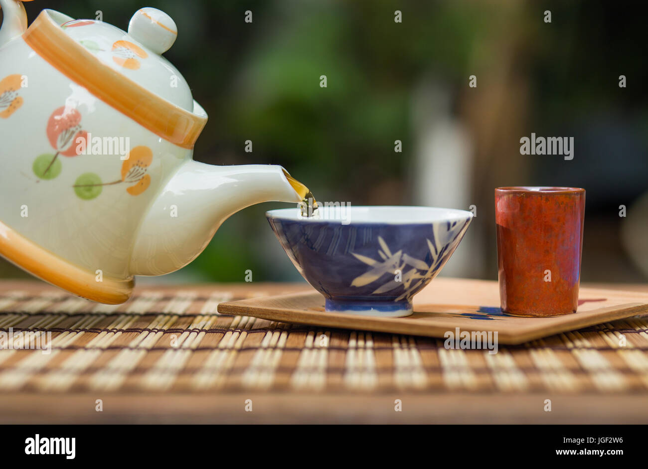 Pouring tea with teapot on wooden table , breaking time Stock Photo - Alamy