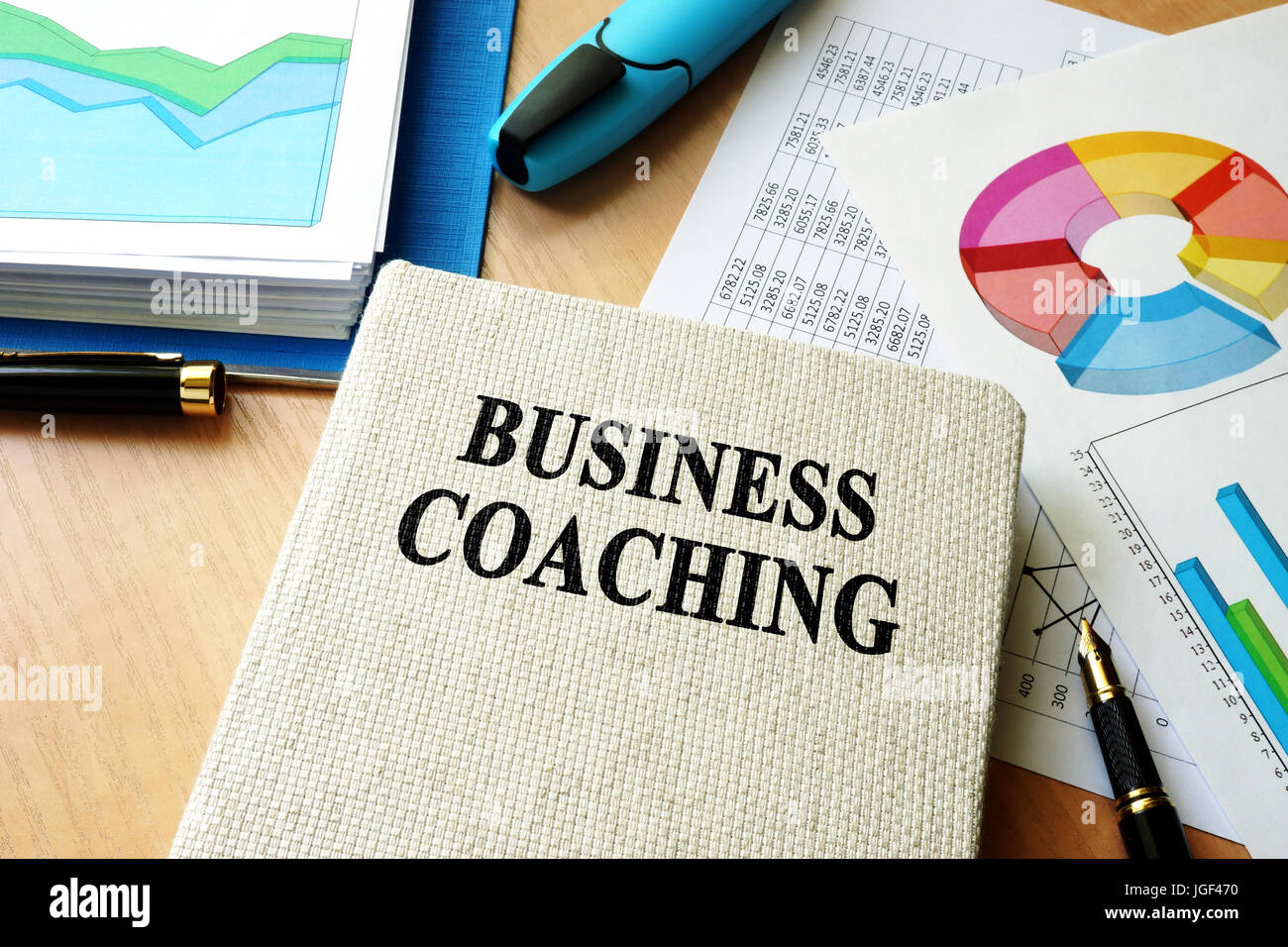 Book with title business coaching in an office Stock Photo - Alamy