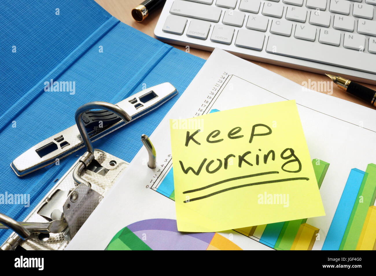 Keep working sign on a piece of paper and documents Stock Photo - Alamy