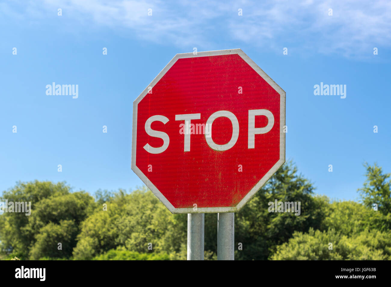 Octagonal red traffic stop sign seen against blue summer sky. Possible ...