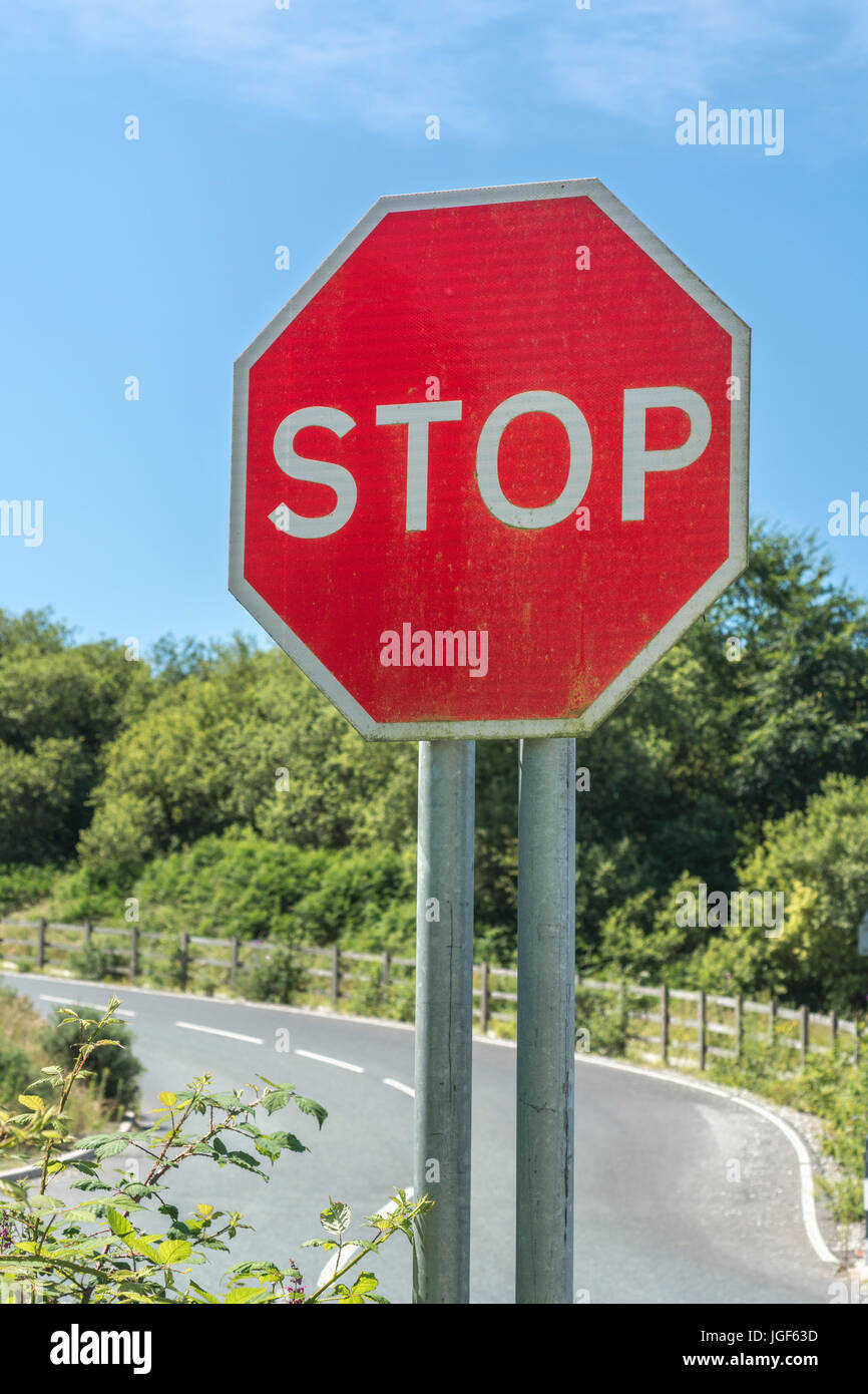 Octagonal red traffic stop sign seen against blue summer sky. Possible ...
