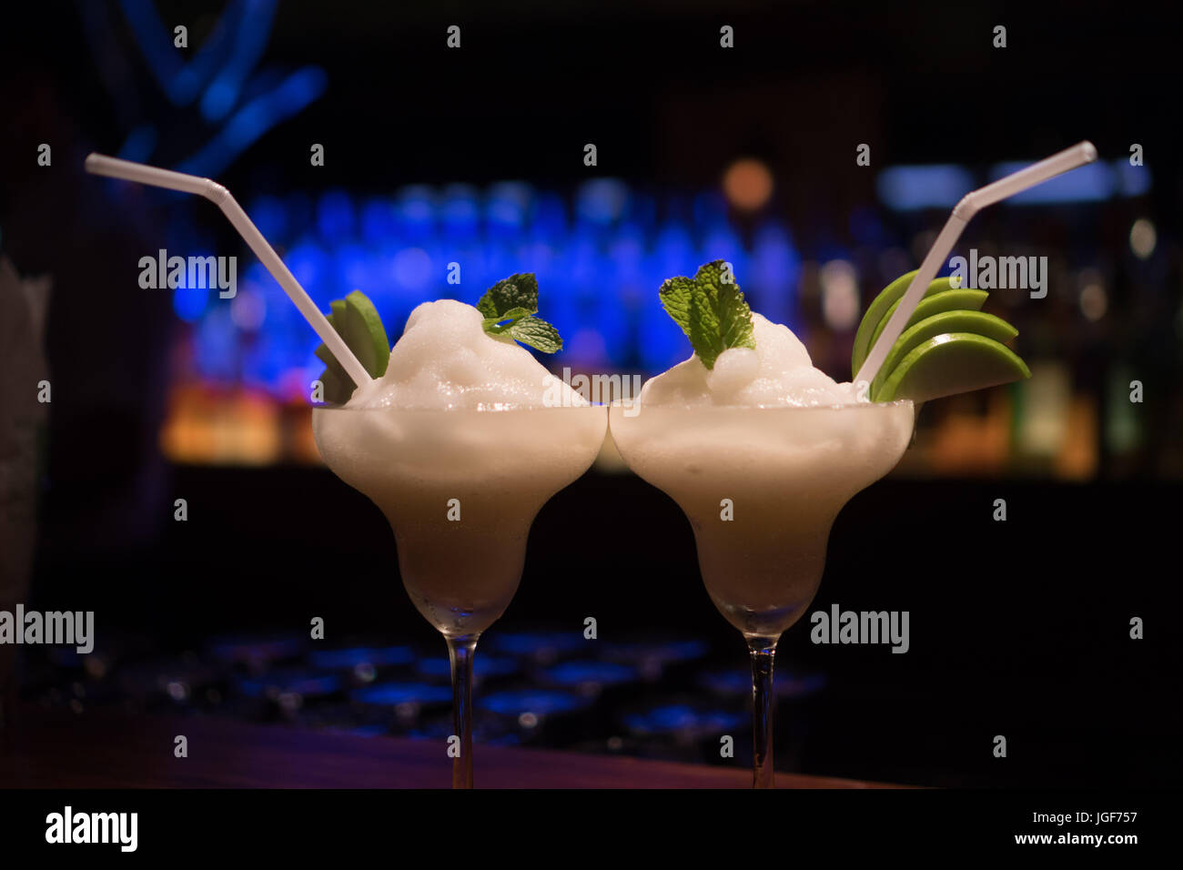 Closeup of two alcohol fruit coctail drinks on the table over blurred ...