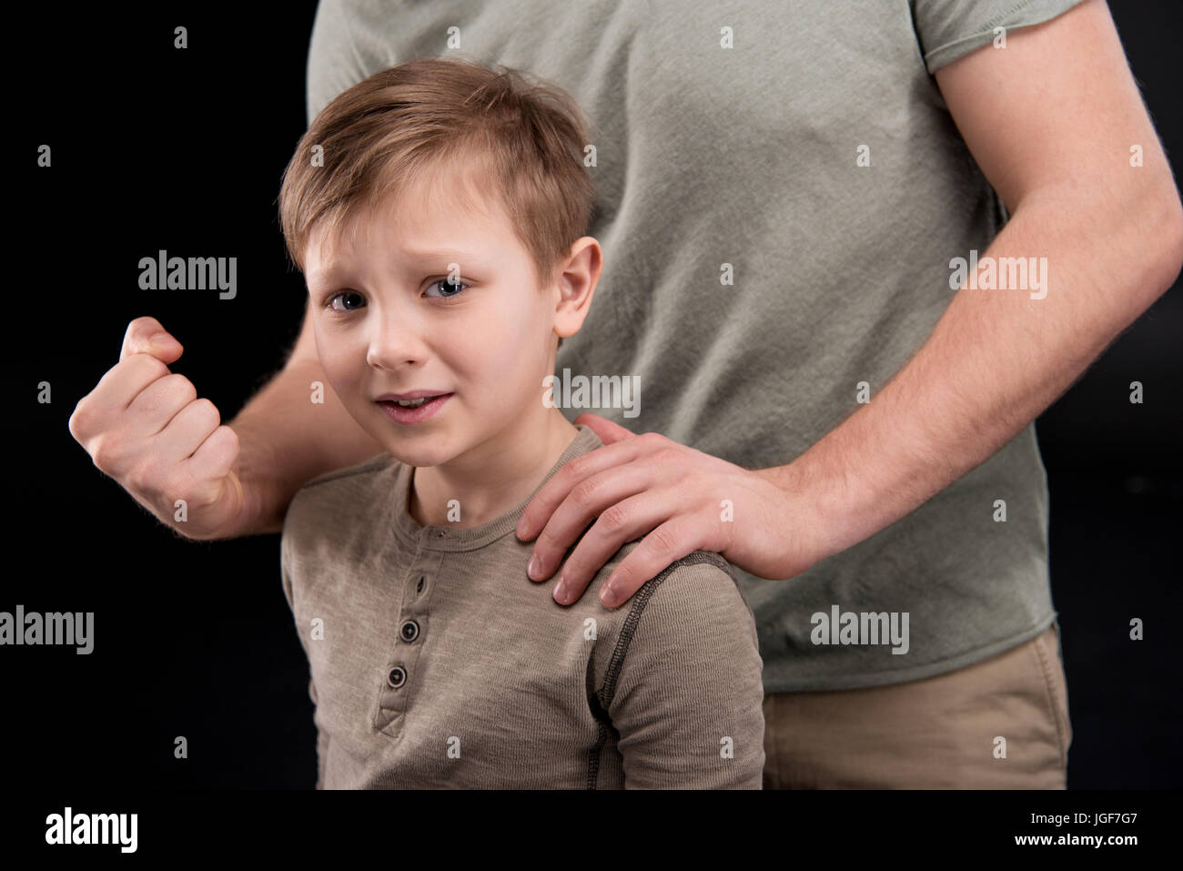 Cropped shot of father threatening and gesturing to scared little son ...