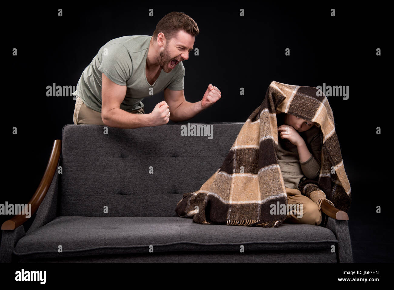 Angry father threatening to scared little boy hiding under blanket on ...