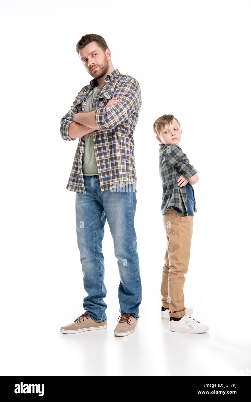 Full length view of serious father and son standing with crossed arms ...