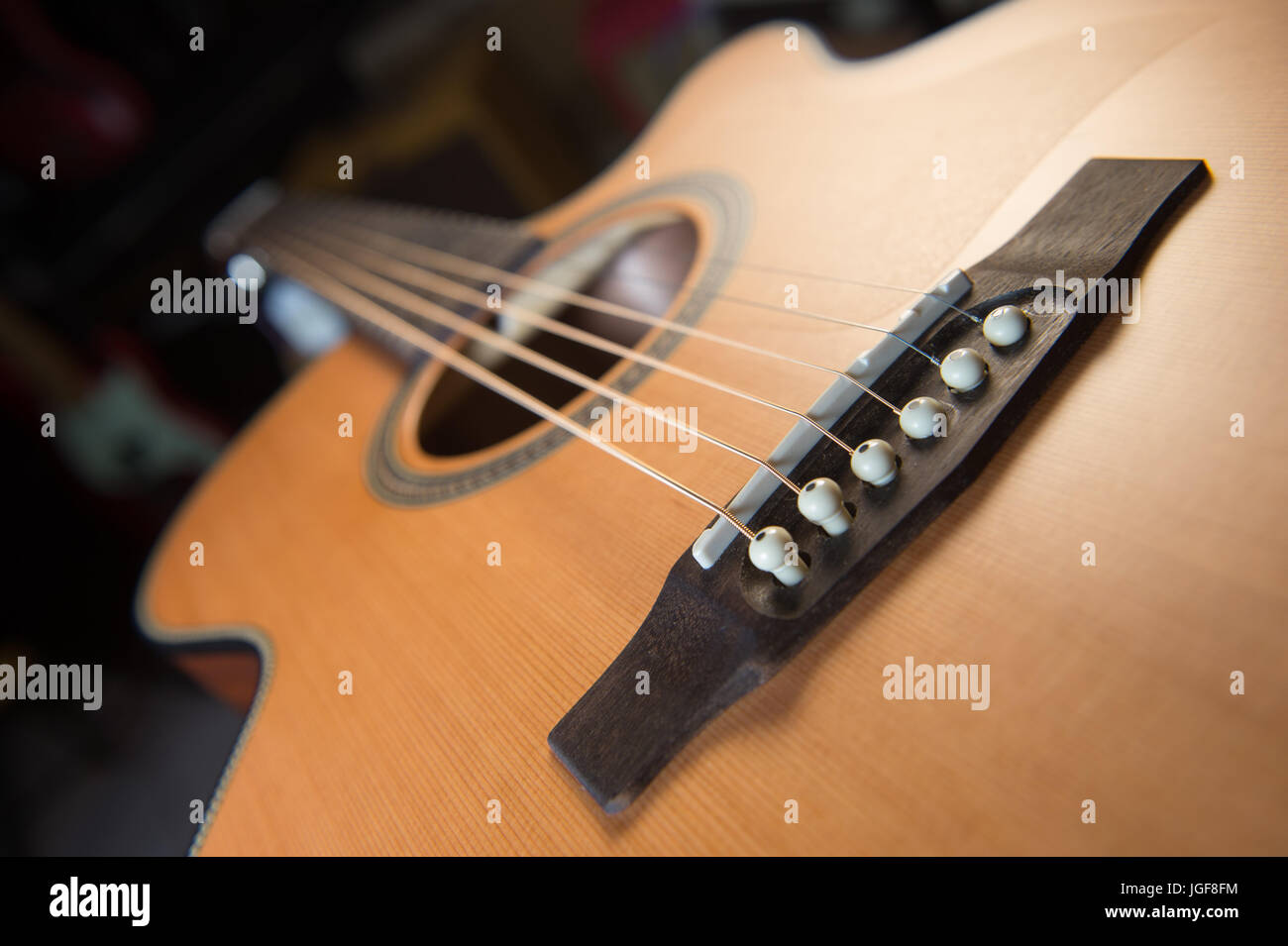 Macro shot down the fretboard of acoustic guitar with shallow depth of ...