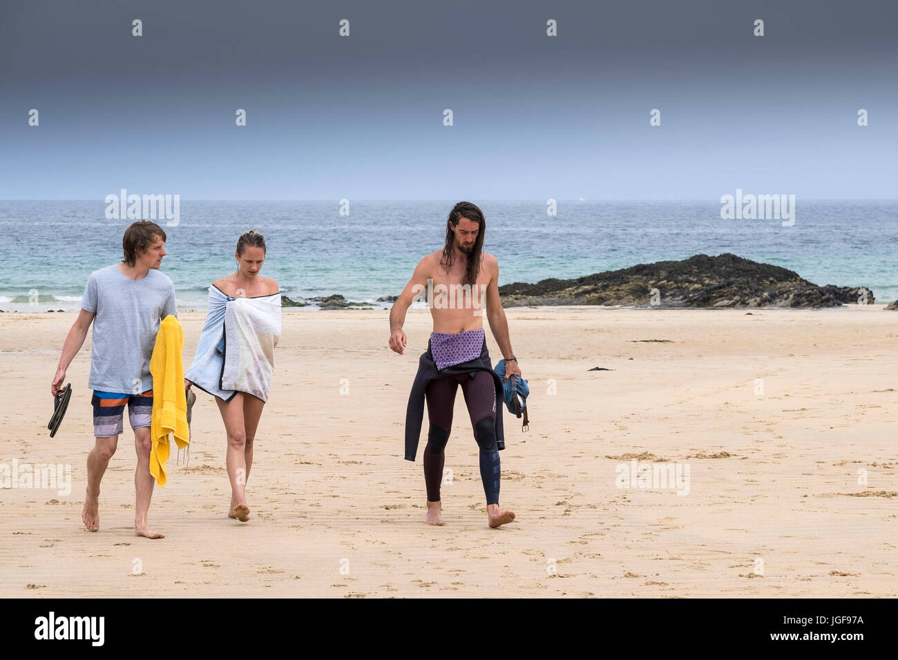 People on the beach. Holidaymakers walking along the beach at Harlyn ...
