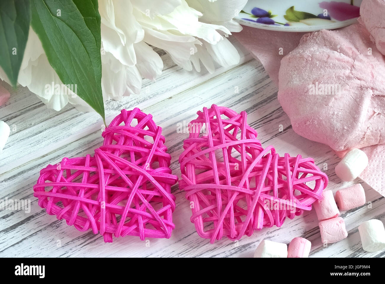 Peonies flowers pink cup of tea rattan hearts marshmallow on a white wooden background - stock ...