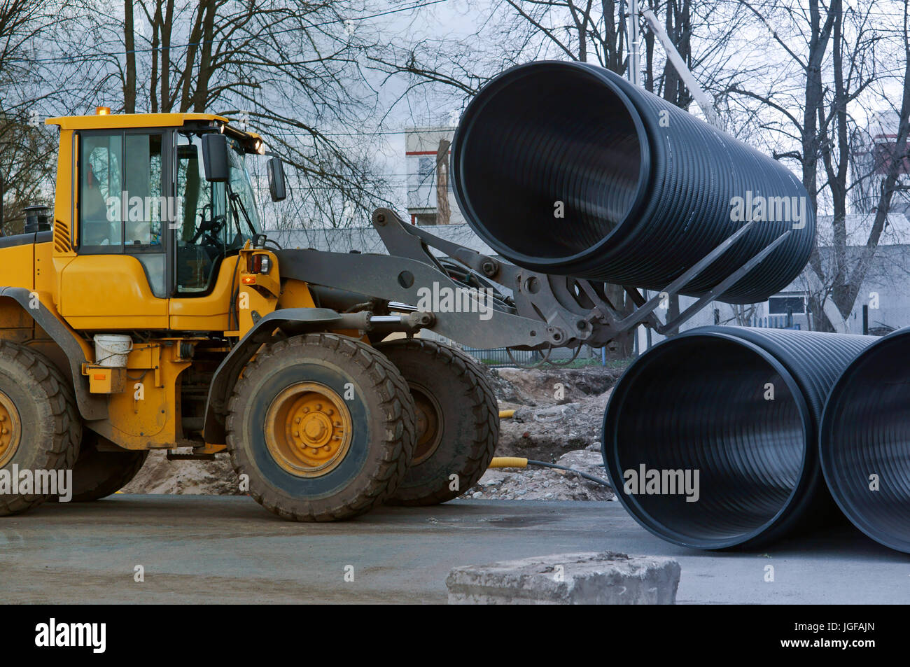 forklift distributes plastic pipes of large diameter Stock Photo - Alamy
