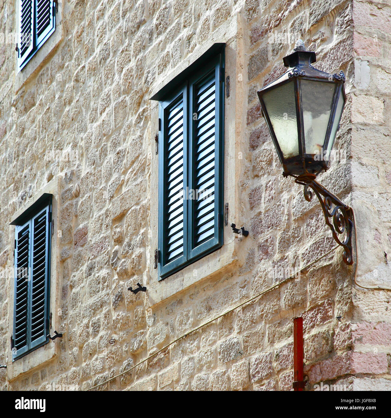 Building with vintage lantern on the corner in Old town of Kotor ...