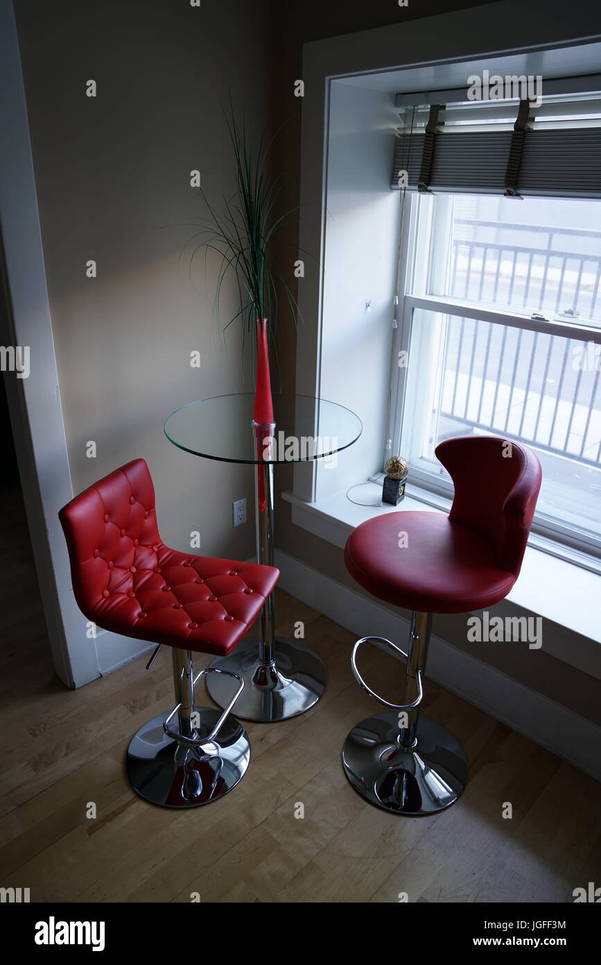 Glass dining table and 2 red chairs in the dining room or living room ...
