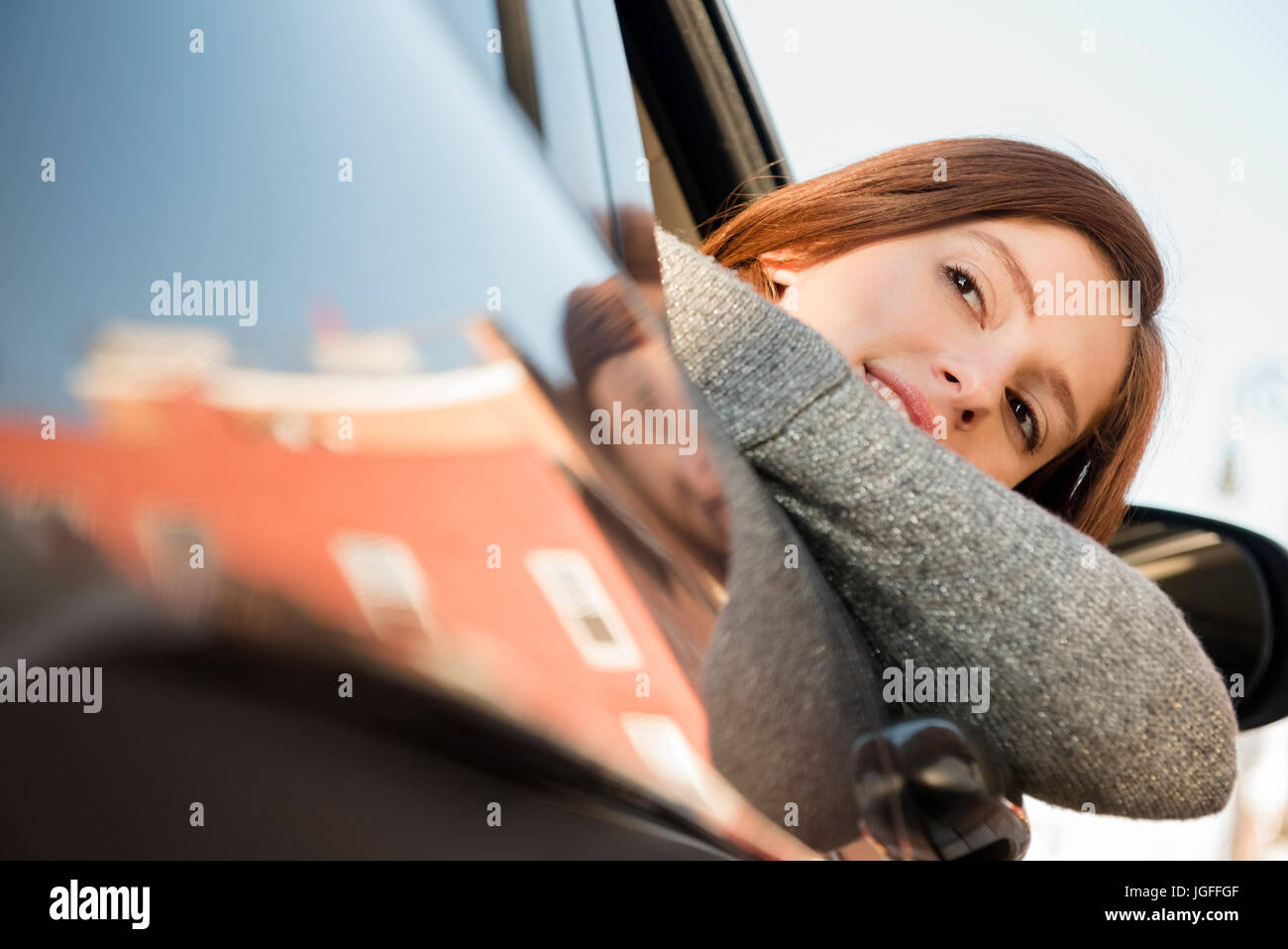 Caucasian woman leaning out car window Stock Photo - Alamy