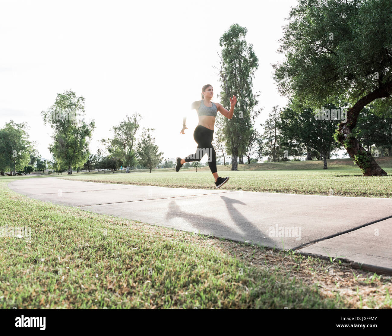 Hispanic woman running on path in park Stock Photo - Alamy