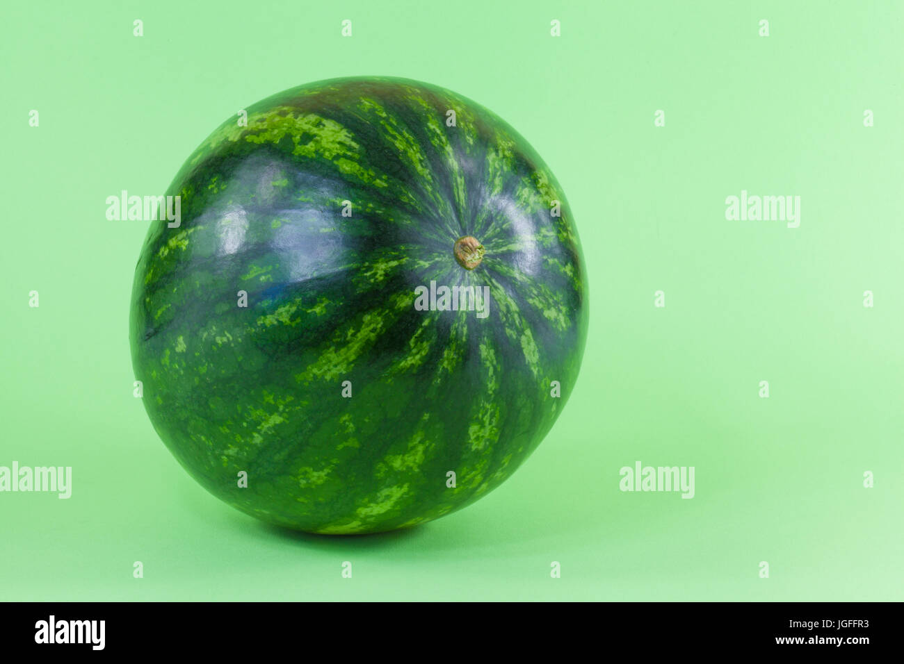 Tiny watermelon isolated on green background Stock Photo - Alamy
