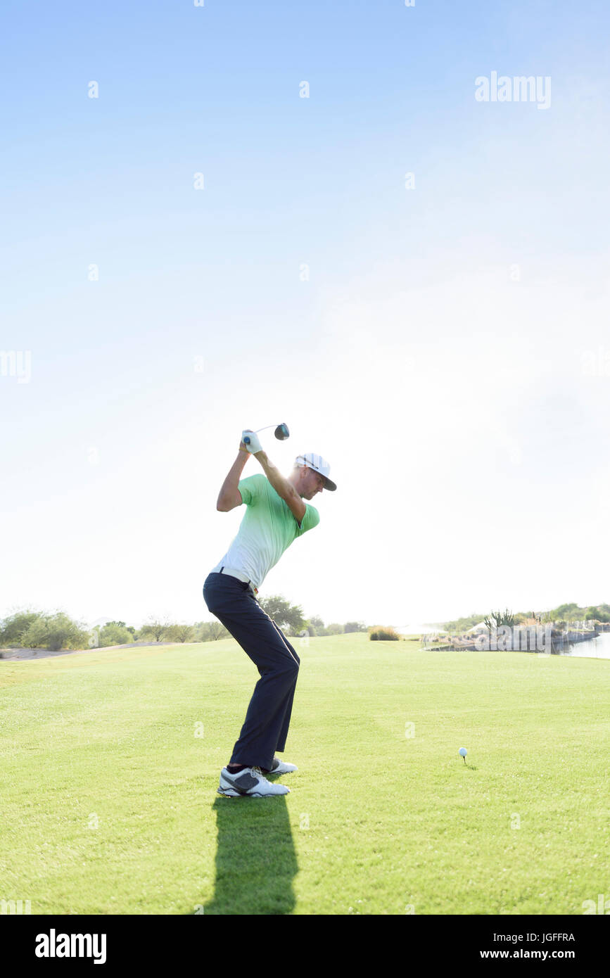 Caucasian man teeing off on golf course Stock Photo - Alamy
