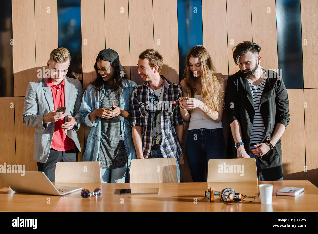 Happy young people standing near the wall in the room and look at the ...