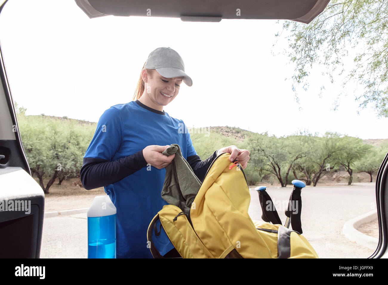 Caucasian woman pulling blanket from backpack in car Stock Photo - Alamy
