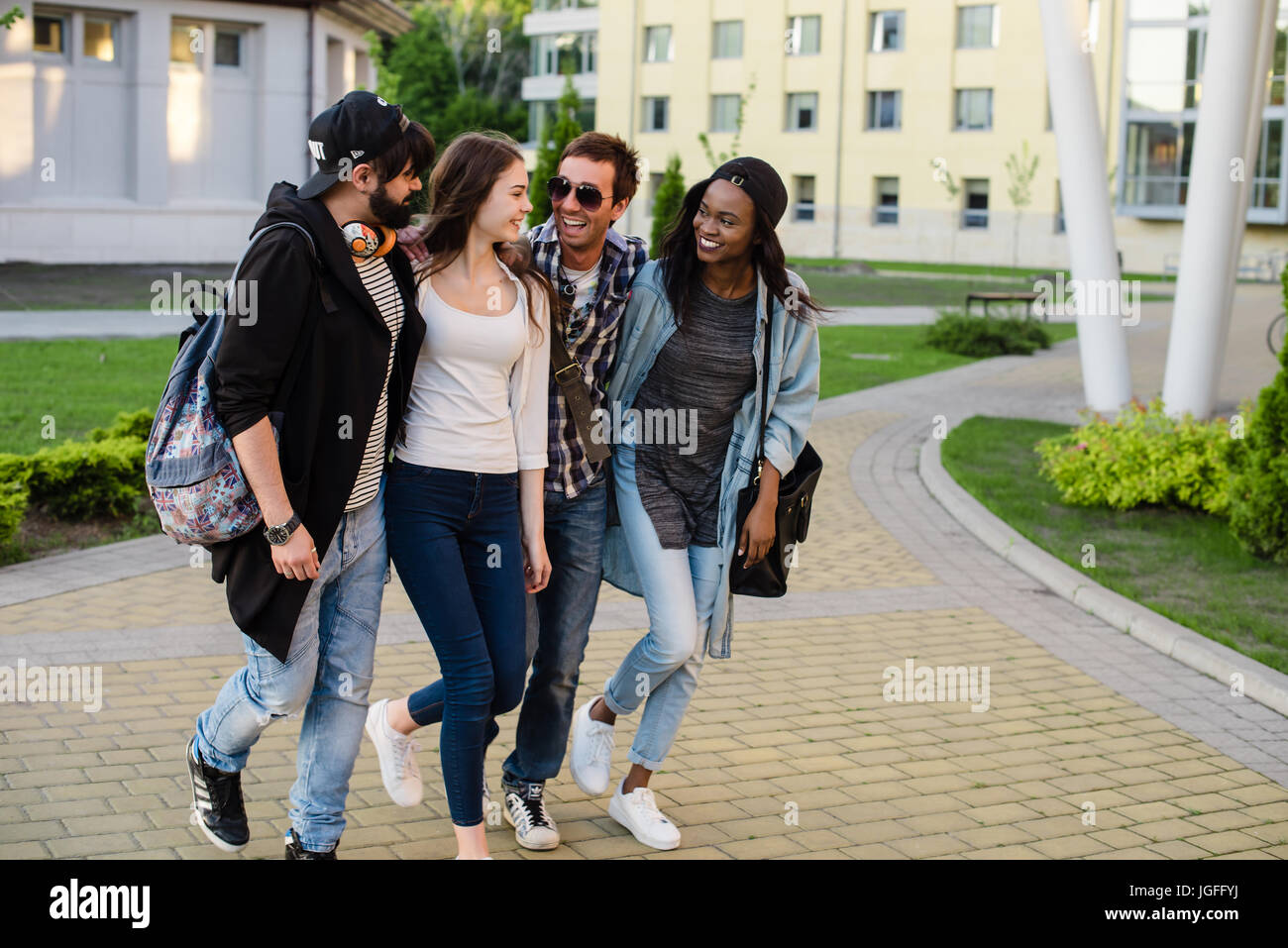Smiled young people walking on the campus and having fun. Casual ...