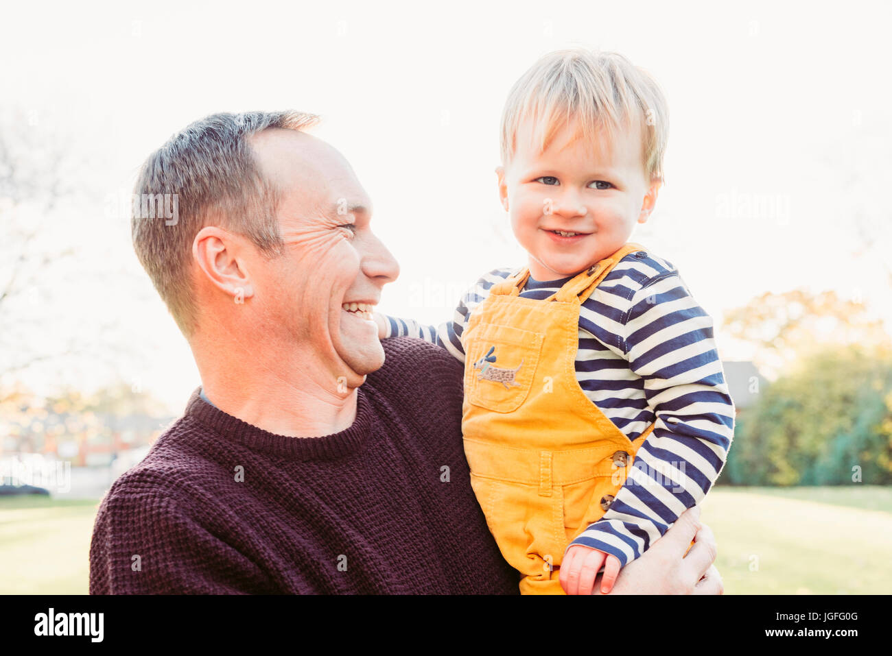Laughing Caucasian father holding son Stock Photo - Alamy