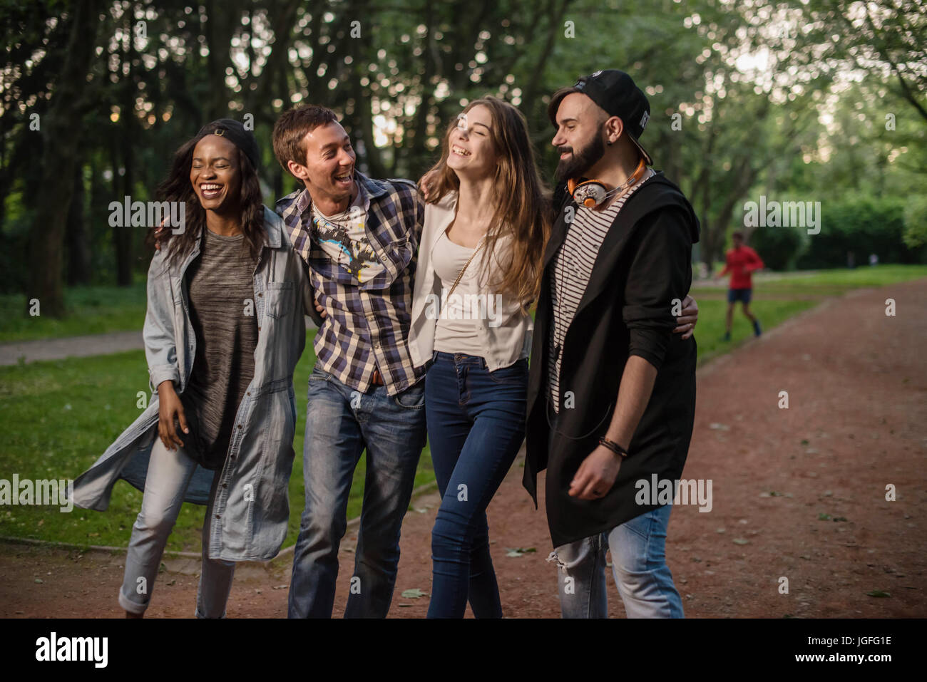 Four happy students walking in then park after working day. Students ...