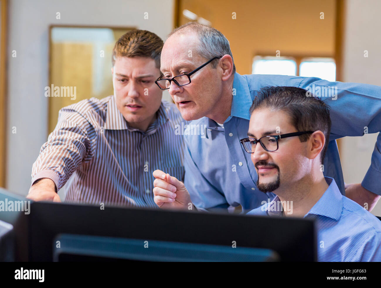 Businessmen talking in office near computer Stock Photo - Alamy