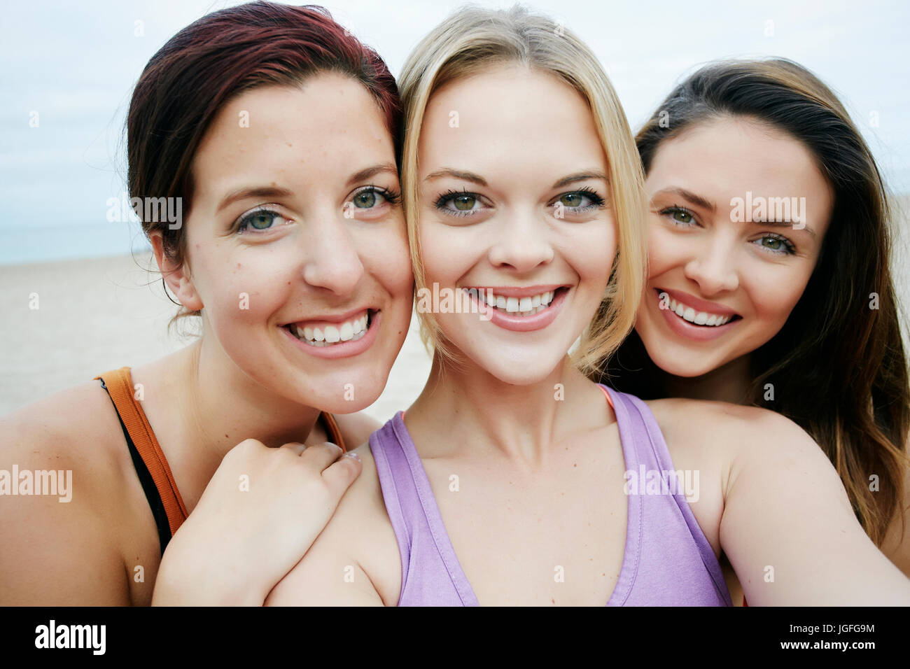 Portrait of smiling Caucasian women cheek to cheek on beach Stock Photo ...