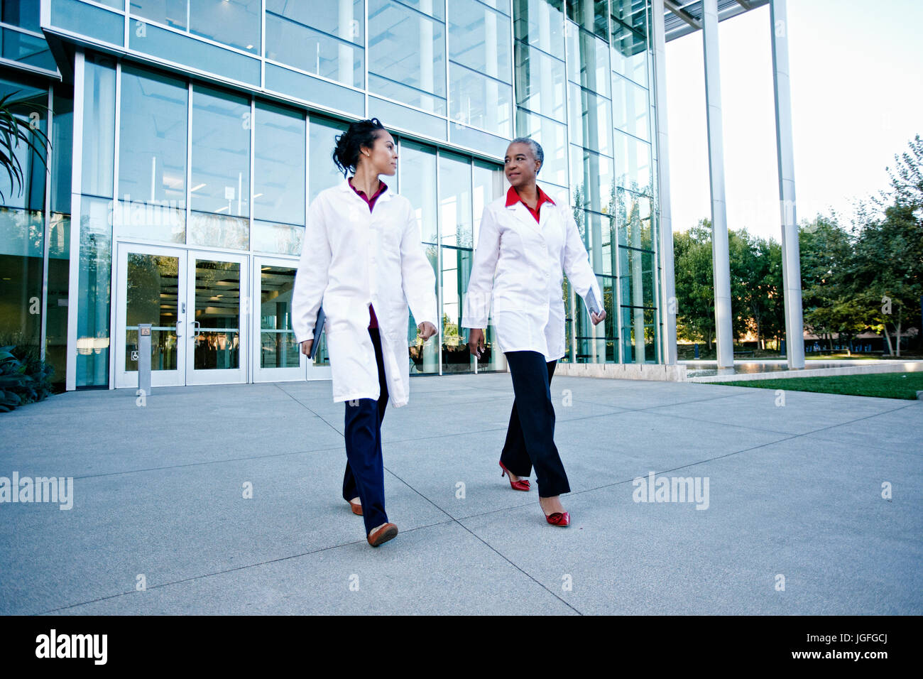 Doctors walking and talking outdoors at hospital Stock Photo - Alamy