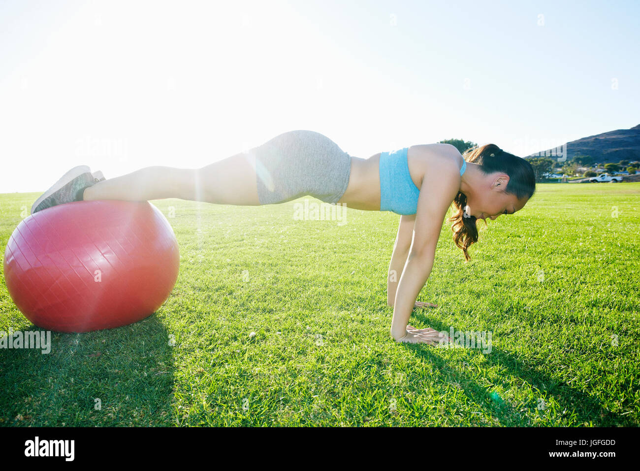 Mixed Race woman balancing on fitness ball doing push-ups Stock Photo ...