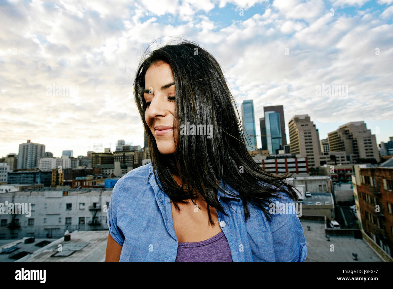 Portrait of smiling Hispanic woman on urban rooftop Stock Photo - Alamy