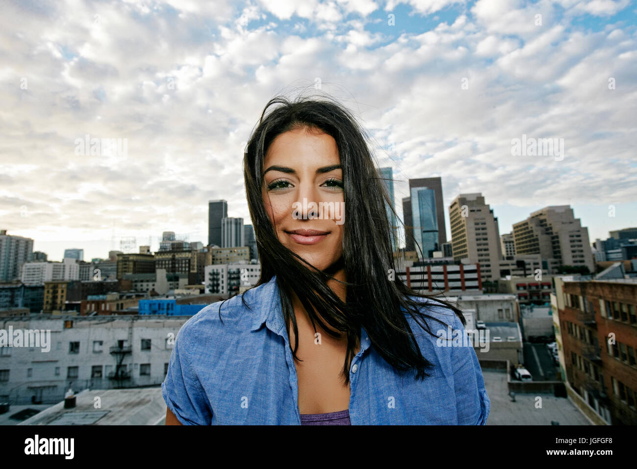 Portrait of smiling Hispanic woman on urban rooftop Stock Photo - Alamy