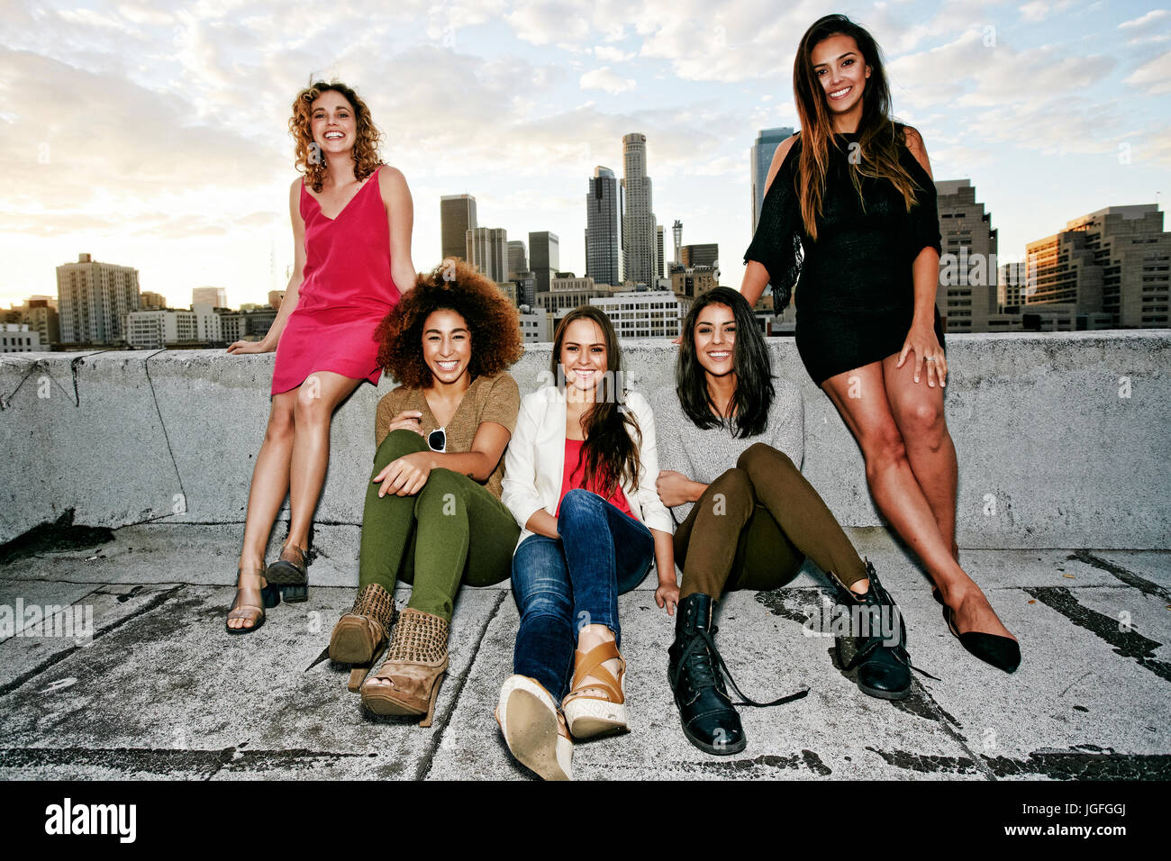 Portrait of smiling women on urban rooftop at sunset Stock Photo - Alamy