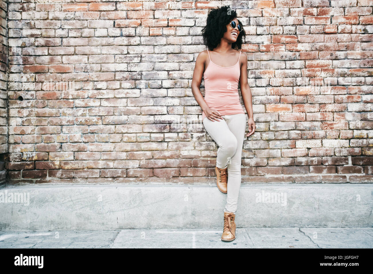 Portrait laughing young woman front brick wall hi-res stock photography ...