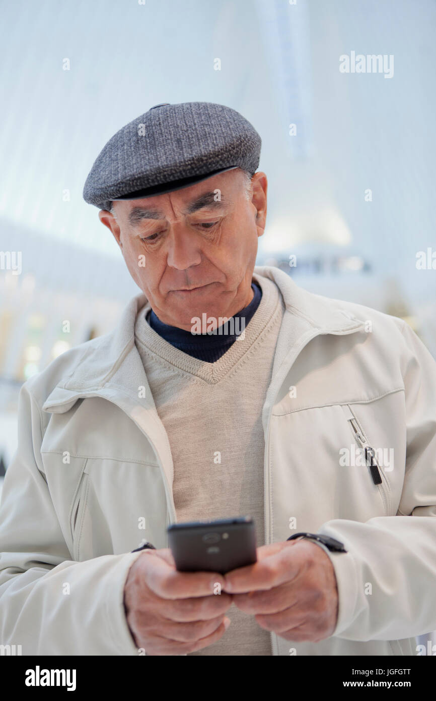 Serious Hispanic man texting on cell phone Stock Photo - Alamy