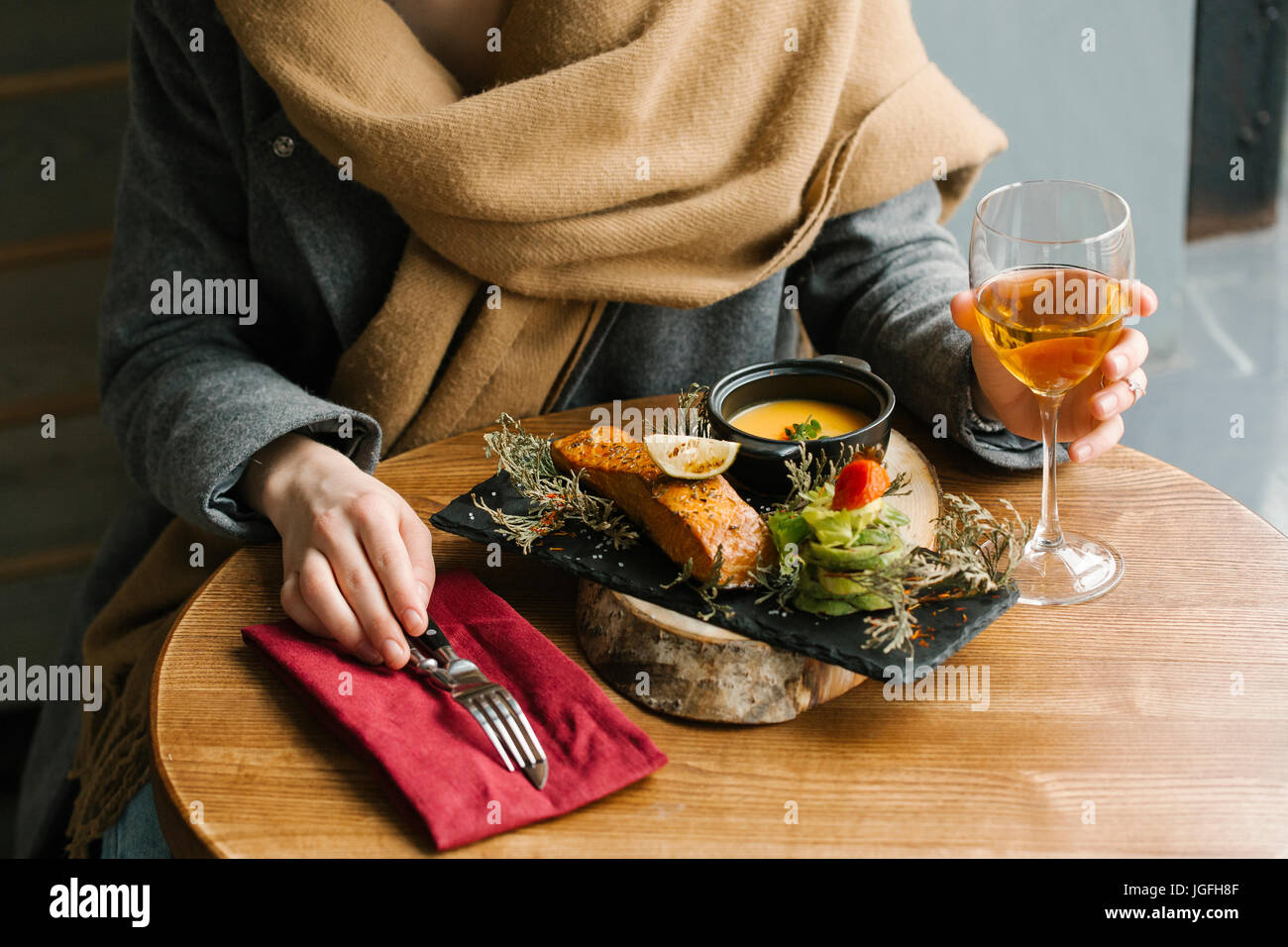 Woman eating fish with white wine Stock Photo - Alamy