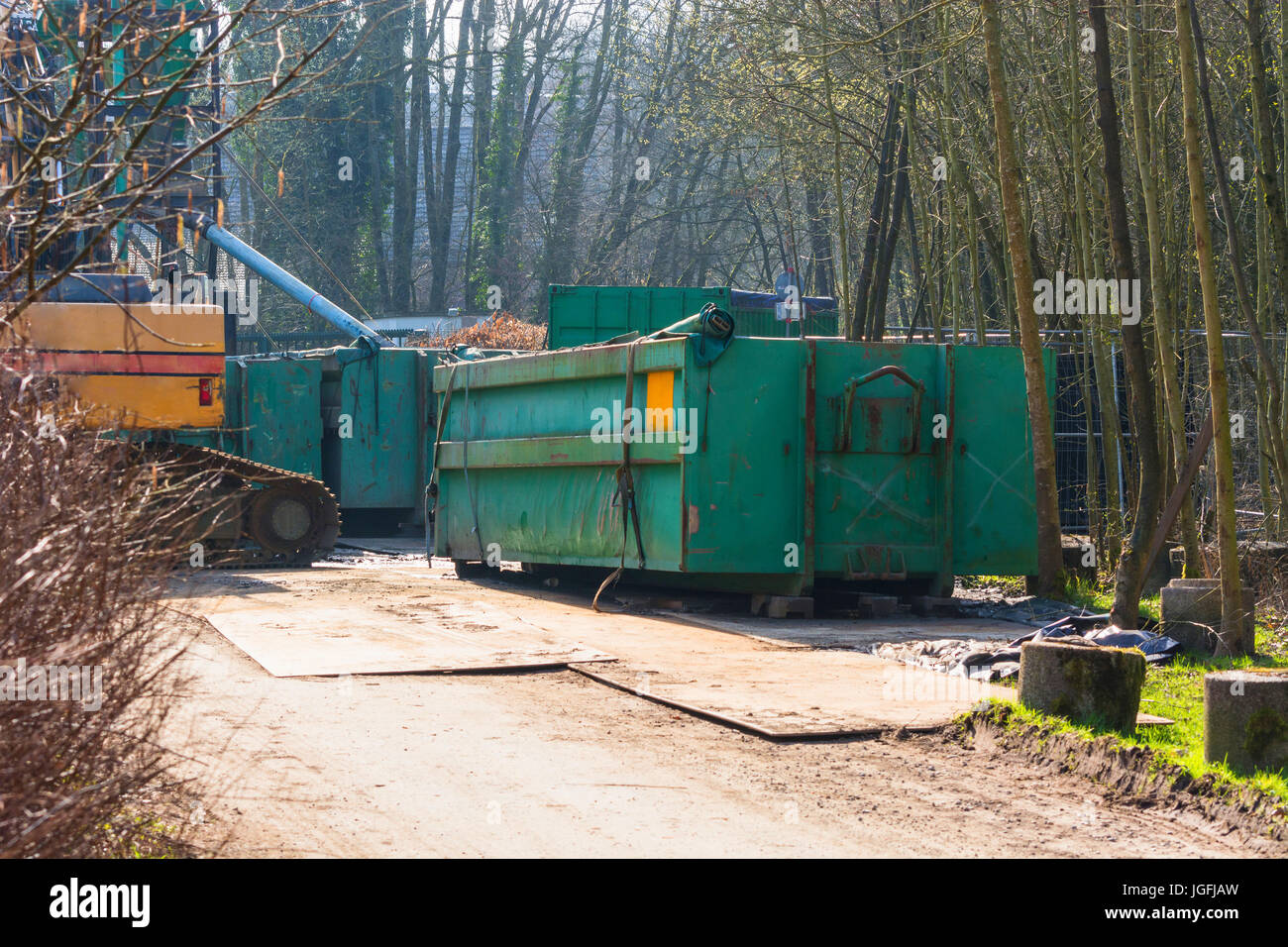 Excavator and green container on a construction site in the forest ...