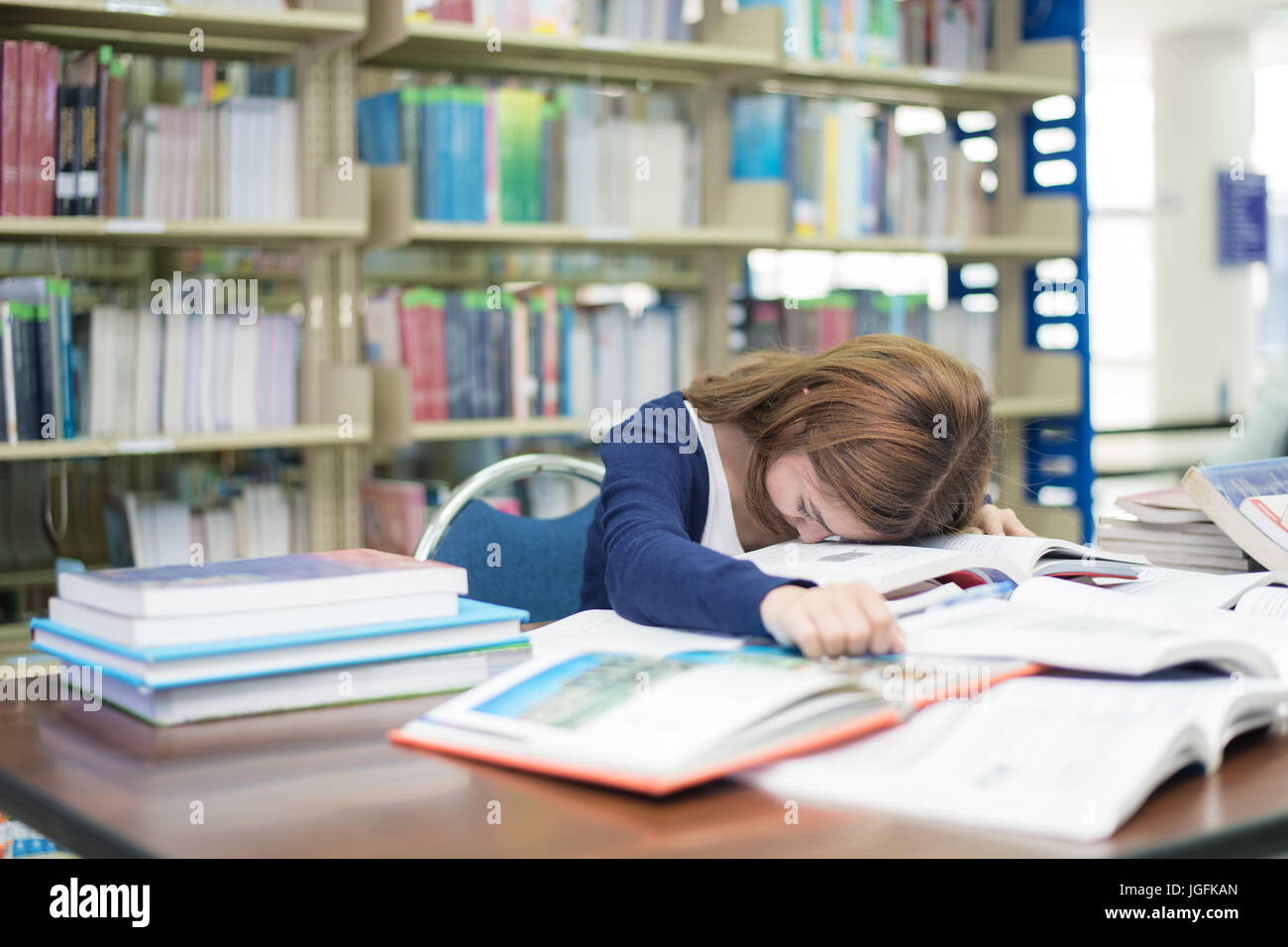 Tired Asian student or young woman with many books sleeping while ...