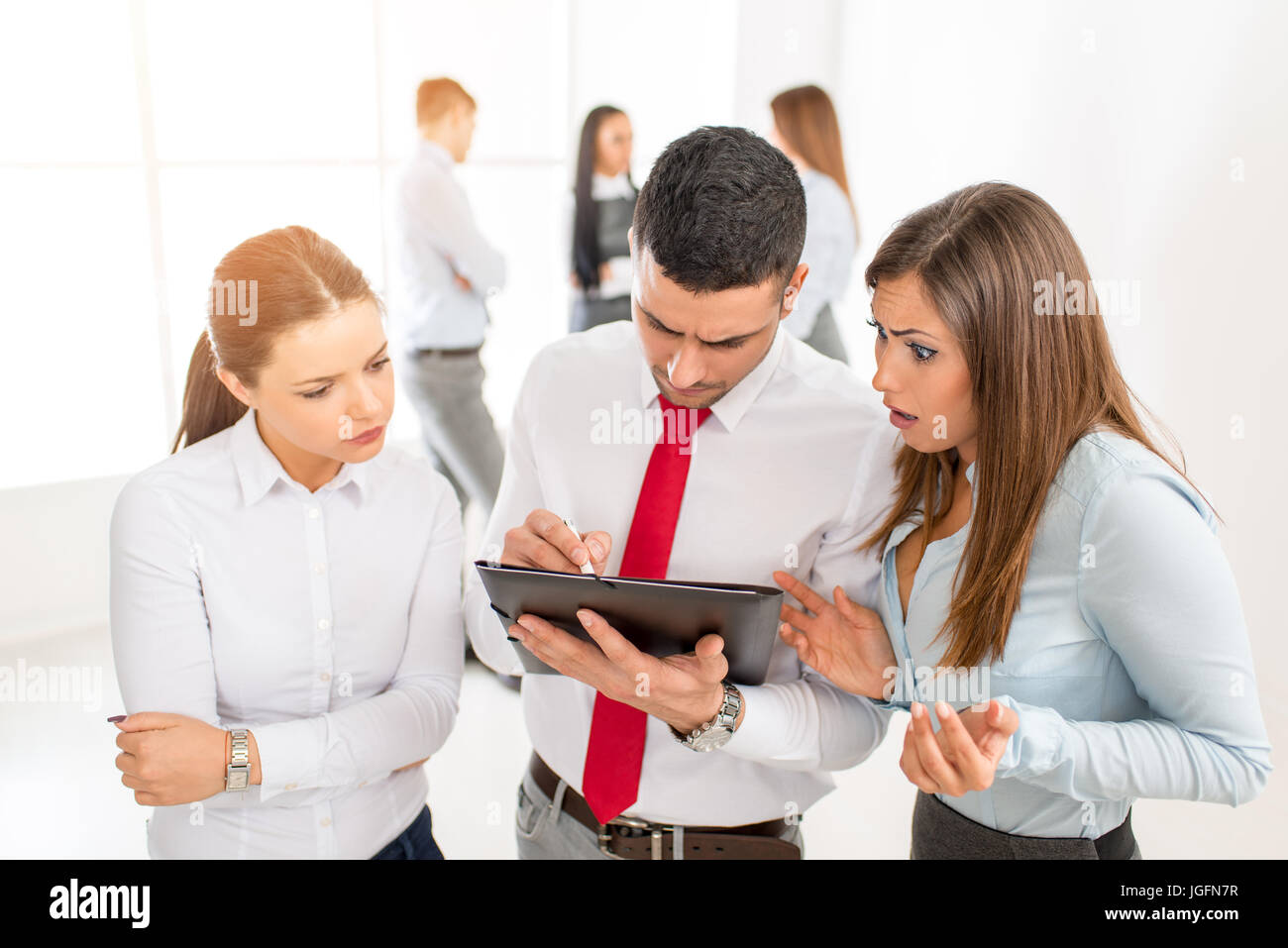Three young colleagues discussing in front their business team Stock ...
