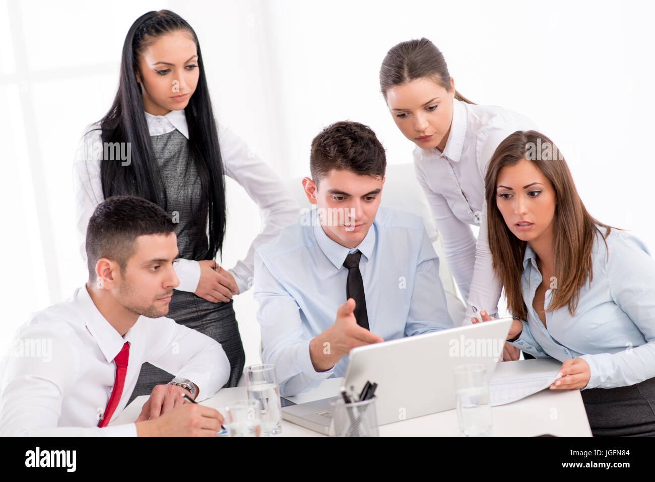 Worried young colleagues working at laptop in the office Stock Photo ...
